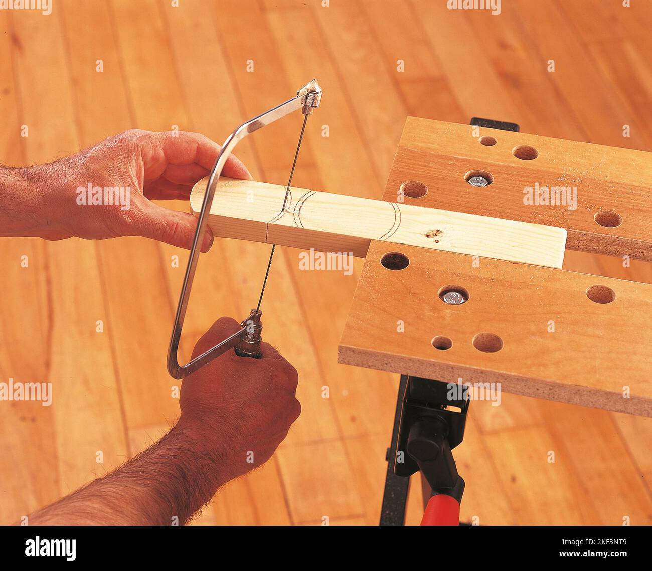 Cutting out a wooden shape with a coping saw Stock Photo - Alamy