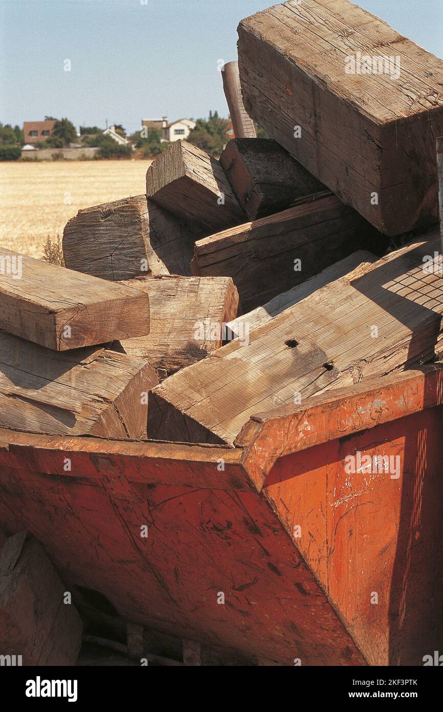 Old wood beams in a red skip container Stock Photo - Alamy