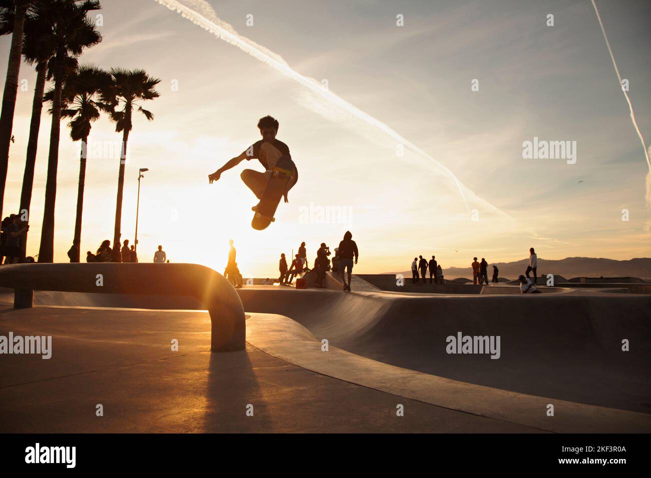 Teenage boy skating at skatepark during sunset Stock Photo - Alamy