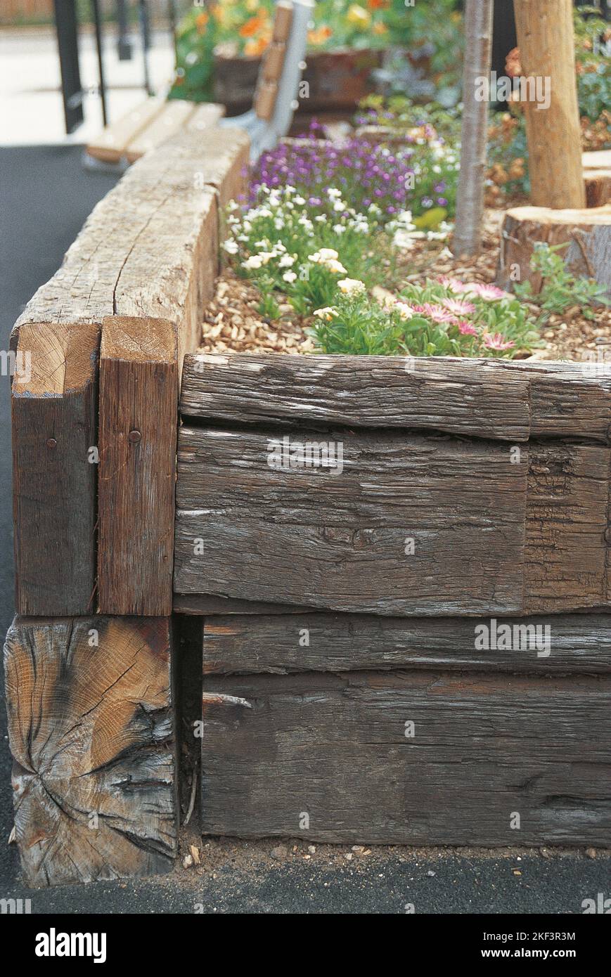 A corner of a garden border made from old wooden boards Stock Photo - Alamy