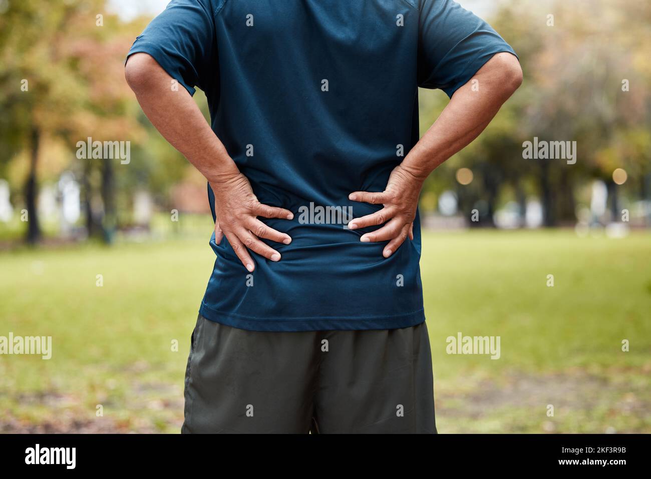 Exercise, fitness and back pain of man at park after workout. Break ...