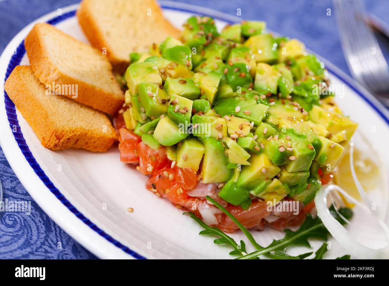 Delicious salmon tartare with avocado, arugula Stock Photo - Alamy