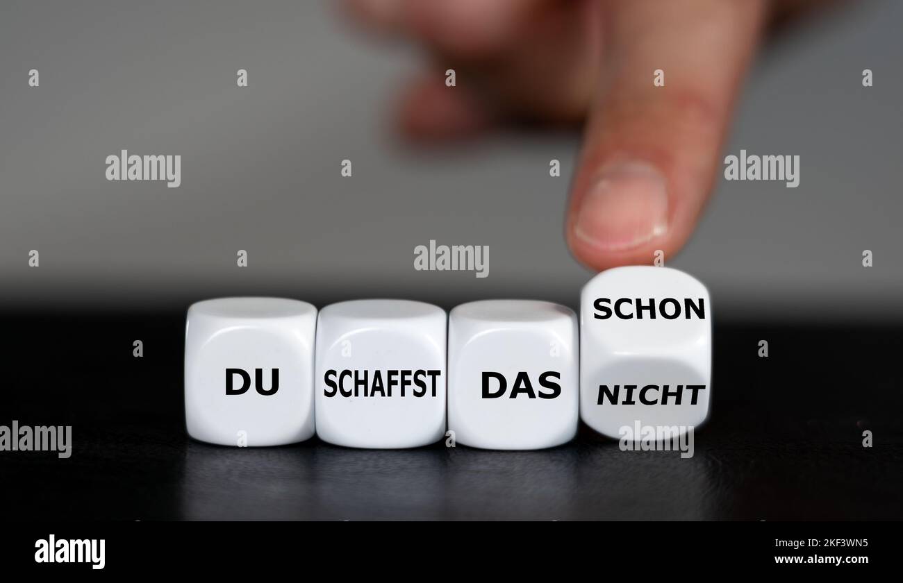 Hand turns dice and changes the German expression 'du schaffst das ...