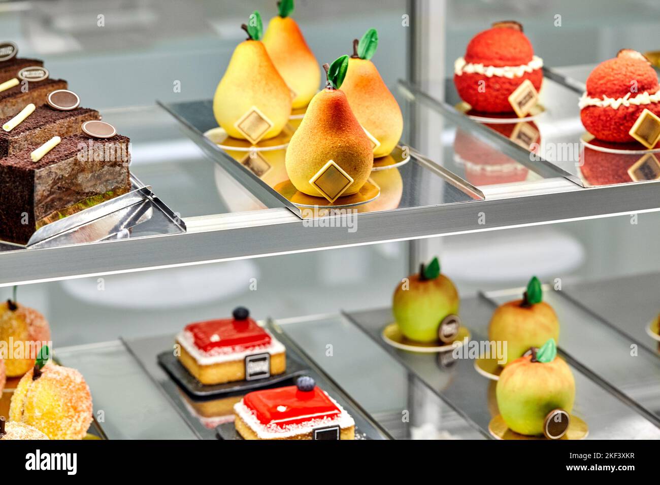 Colorful fruit shaped pastries and cake slices on showcase of pastry ...