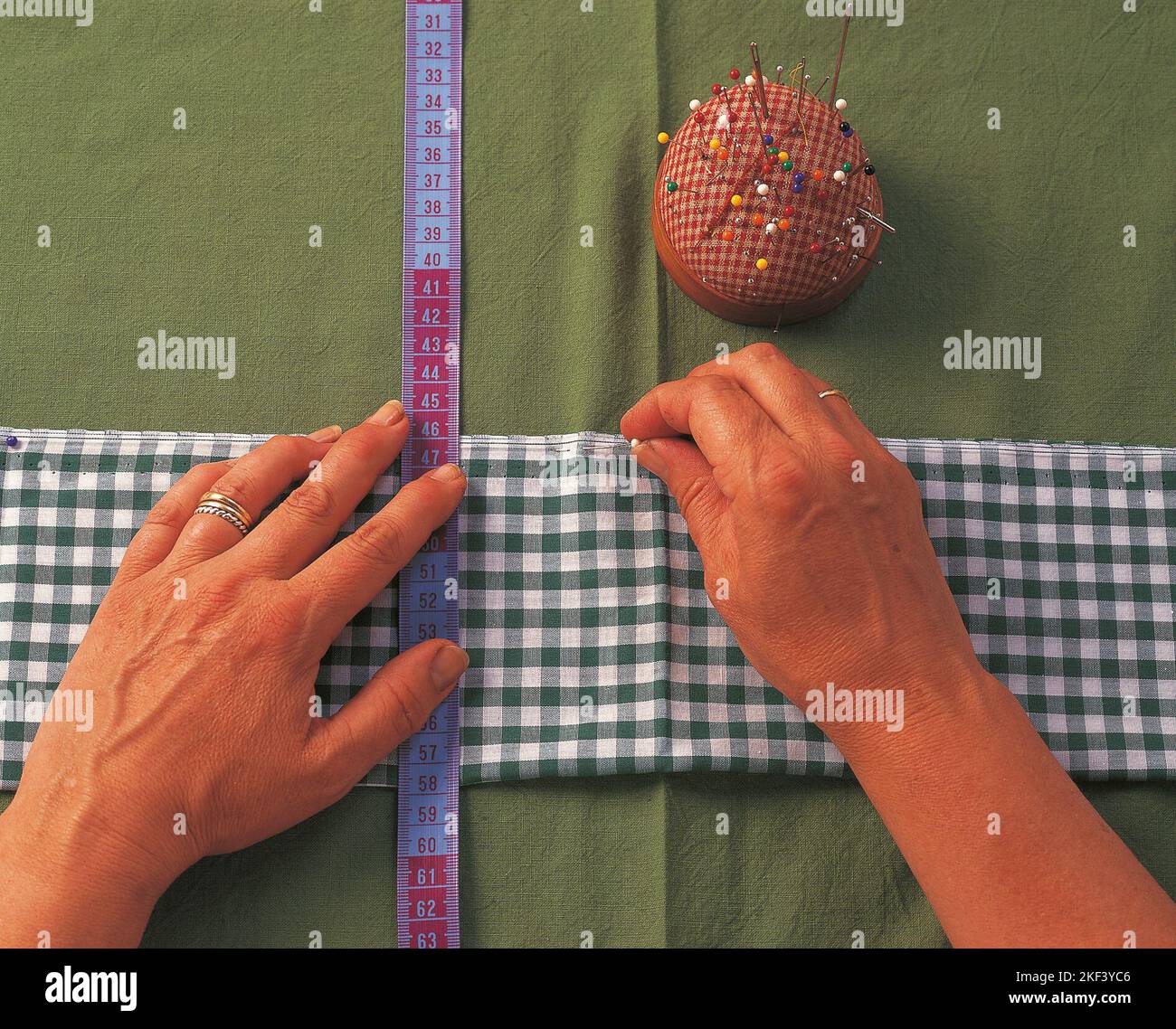 Joining two pieces of fabric with a pin Stock Photo - Alamy