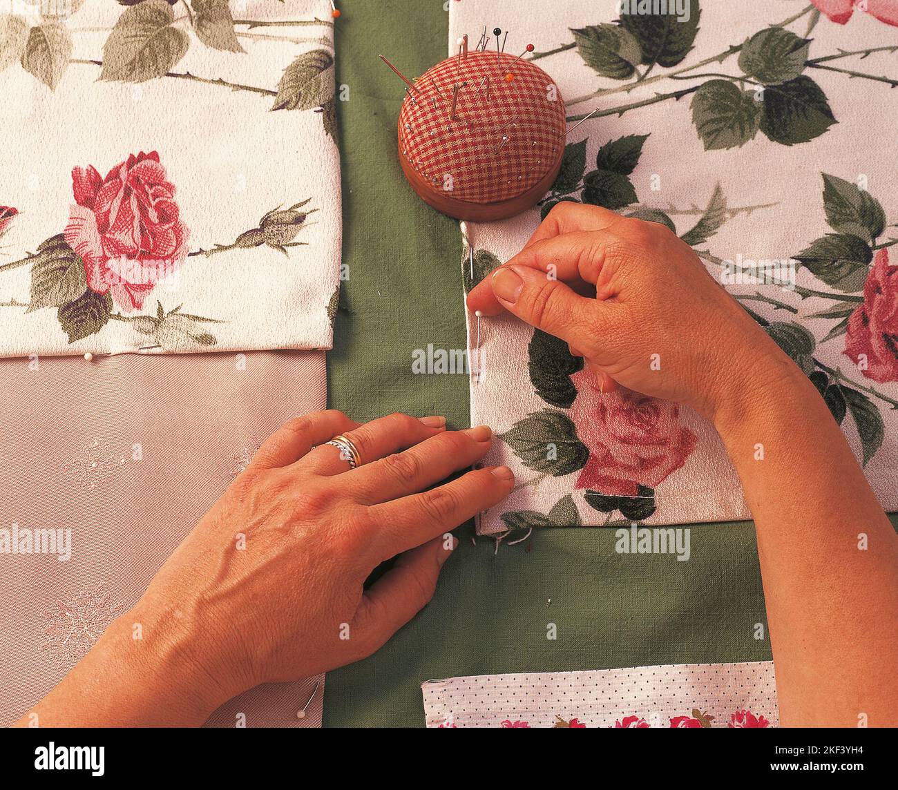 Pushing a sewing pin through a piece of fabric Stock Photo - Alamy