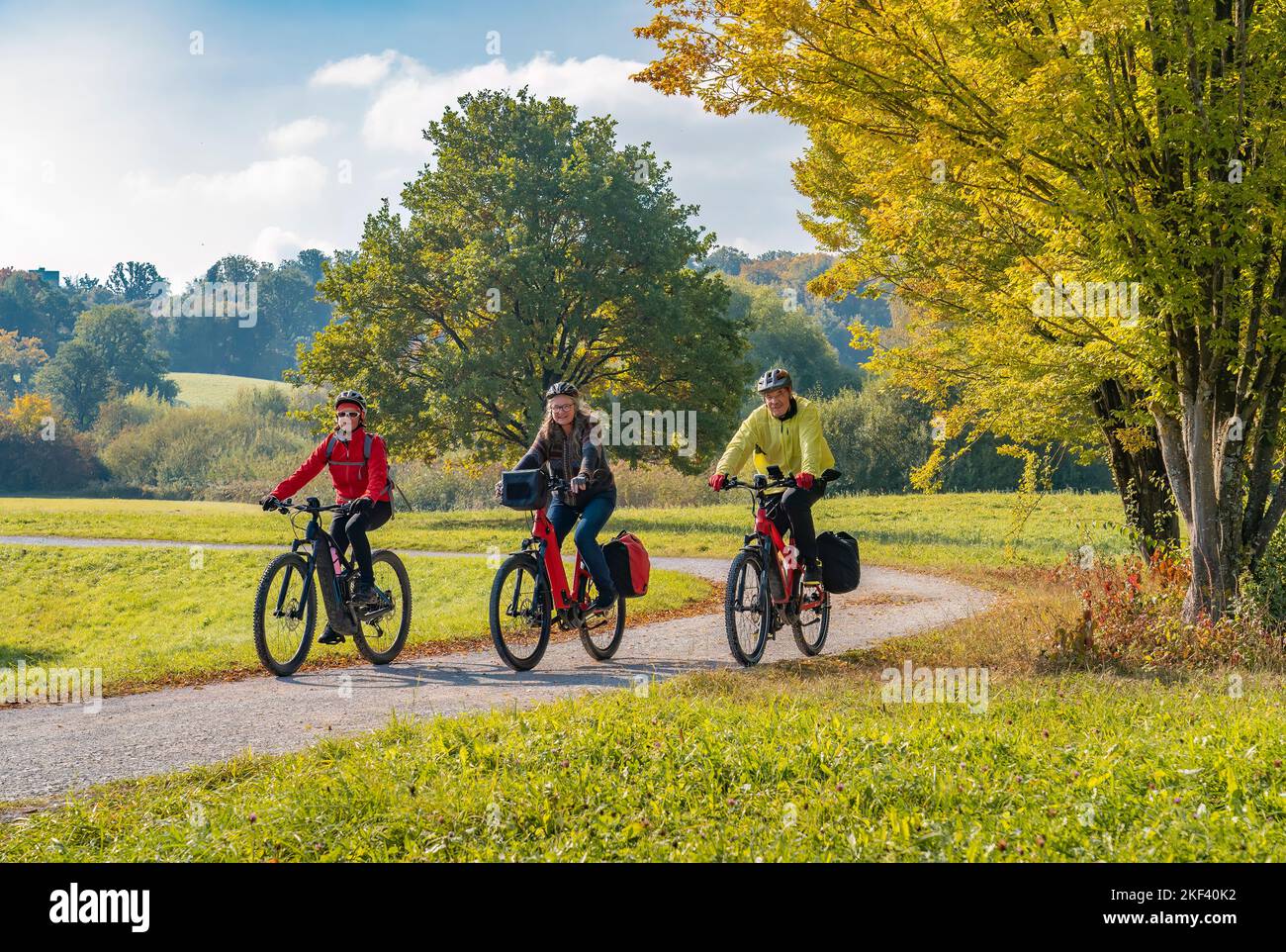 three happy senior adults, riding their mountain bikes in the autumnal ...