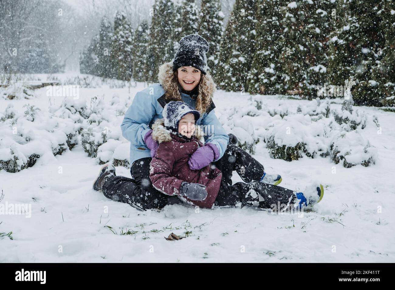 Happy Family, mother and son having fun outdoors in winter snowy nature ...