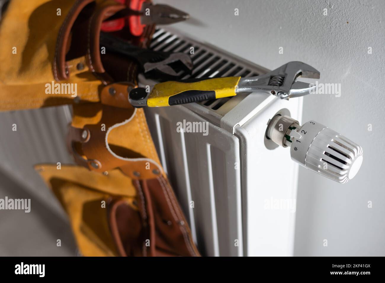 tools on the radiator. water heating radiator on the white wall indoors ...