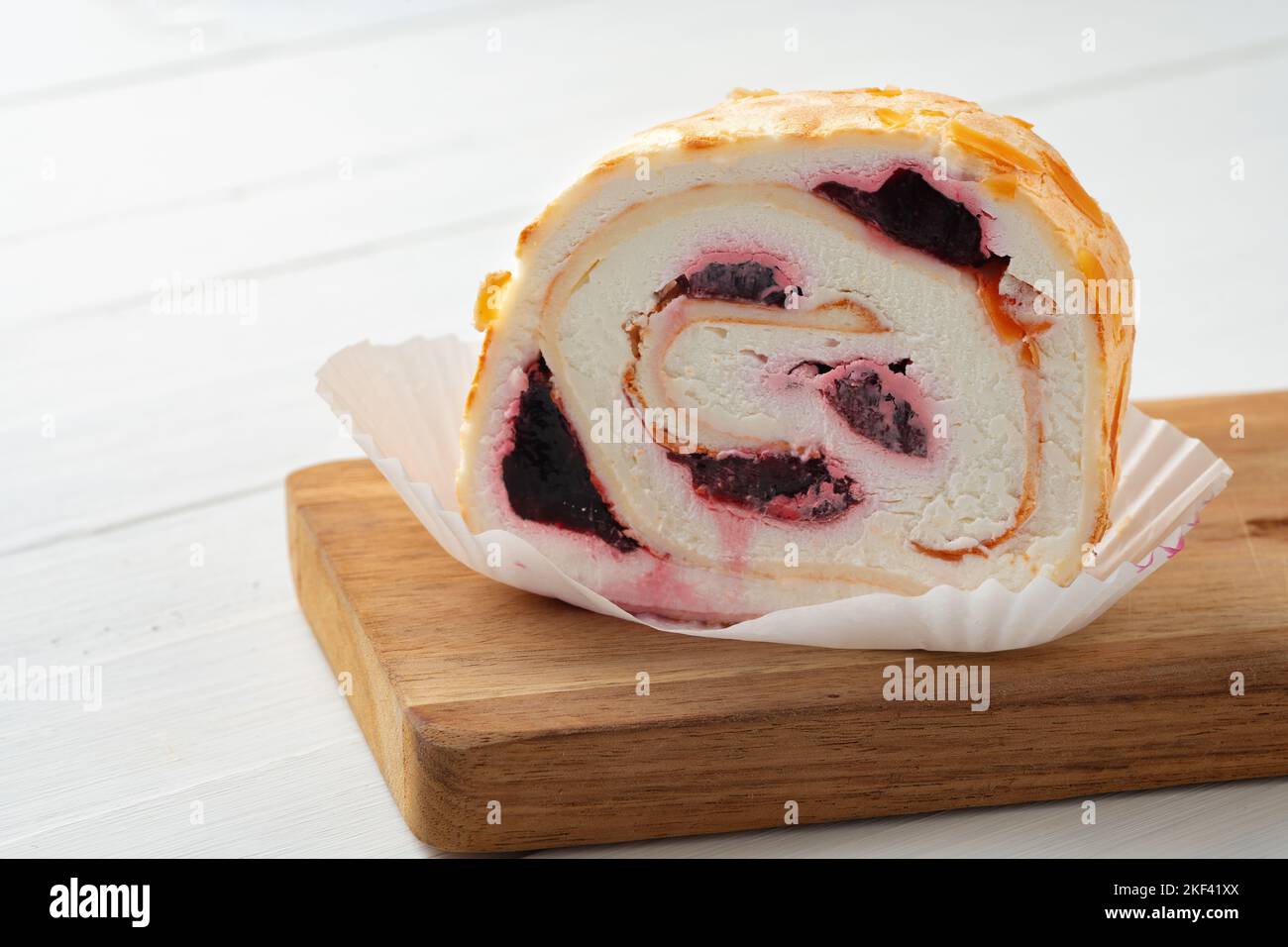 Meringue roll cake with cream on wooden table Stock Photo - Alamy