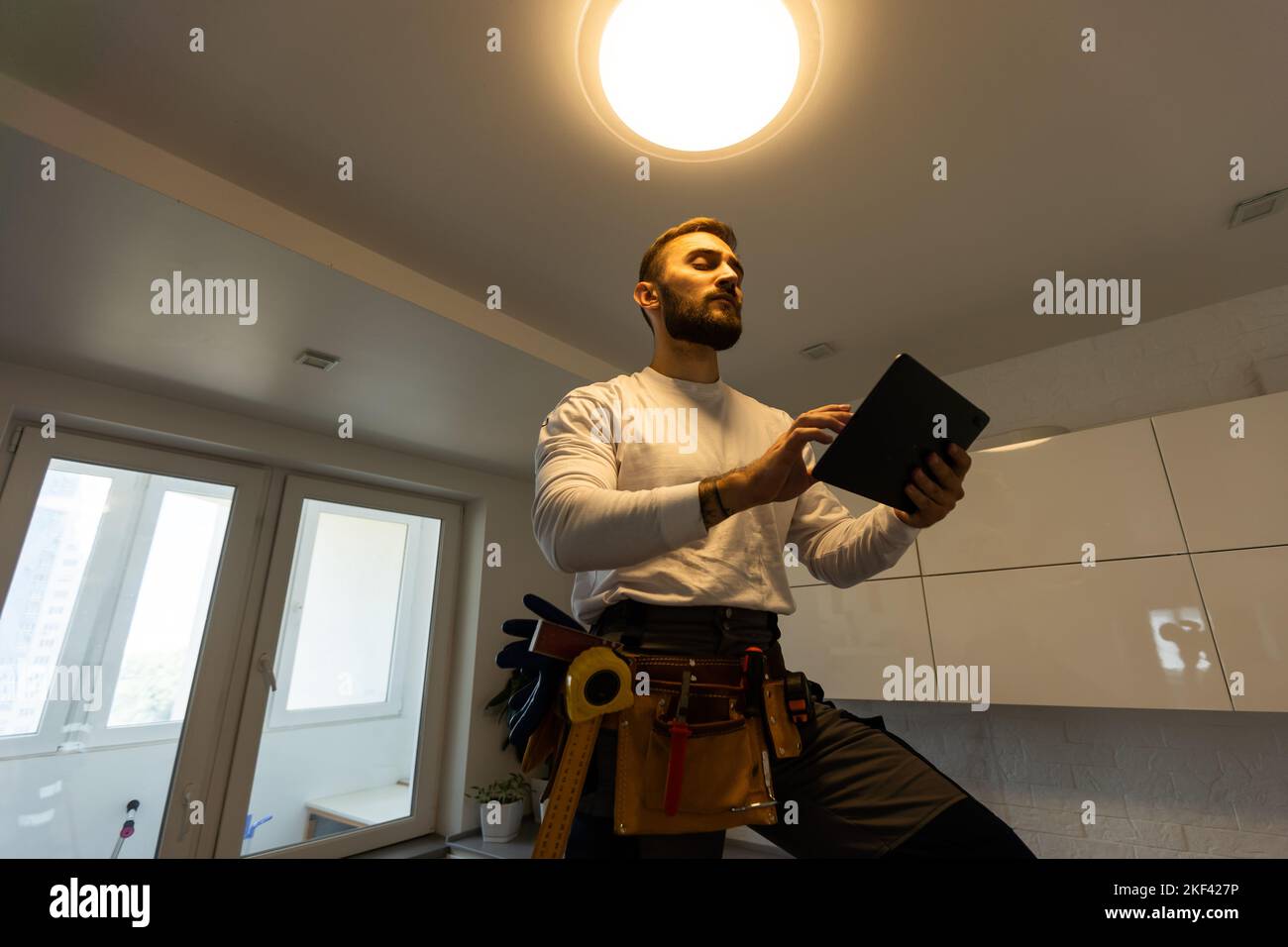 Installation lighting. Builder is holding a tablet in his hands ...