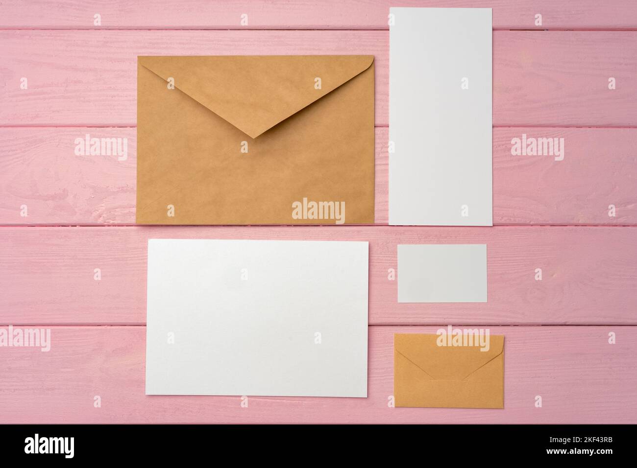 Beige envelope with blank letter on pink wooden desk Stock Photo - Alamy