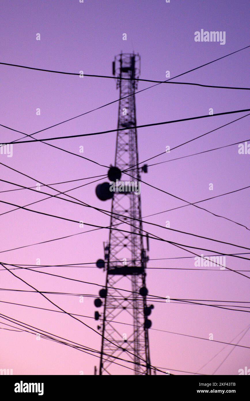 A vertical shot of a telecommunications tower and wires against the ...