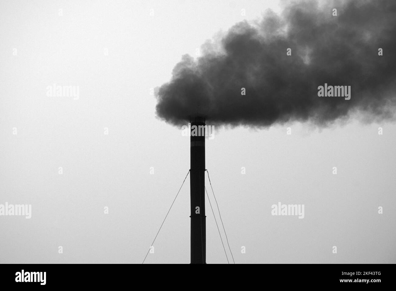 A grayscale shot of a factory emitting black toxic smoke Stock Photo ...