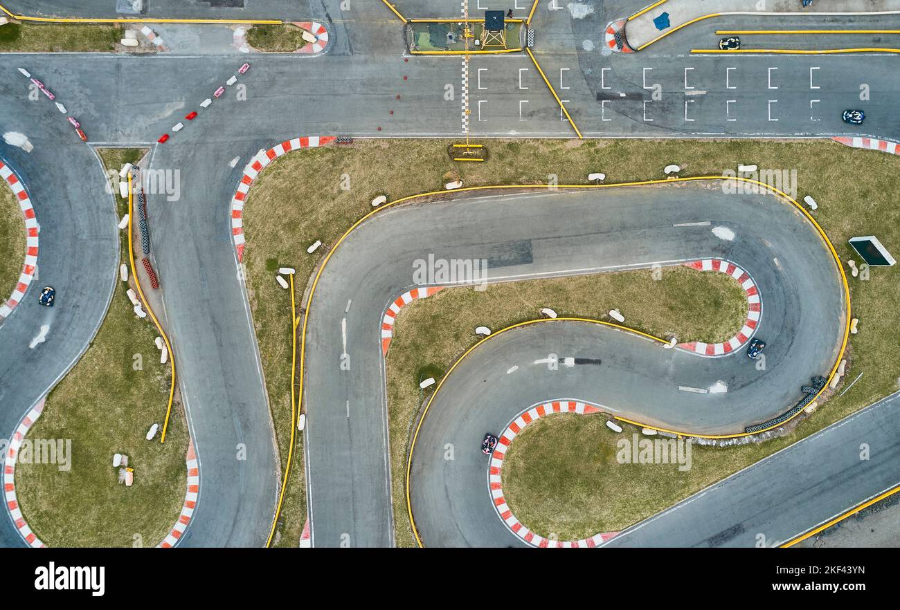 Aerial top view of the go-kart track from the drone. Kart racers drive ...