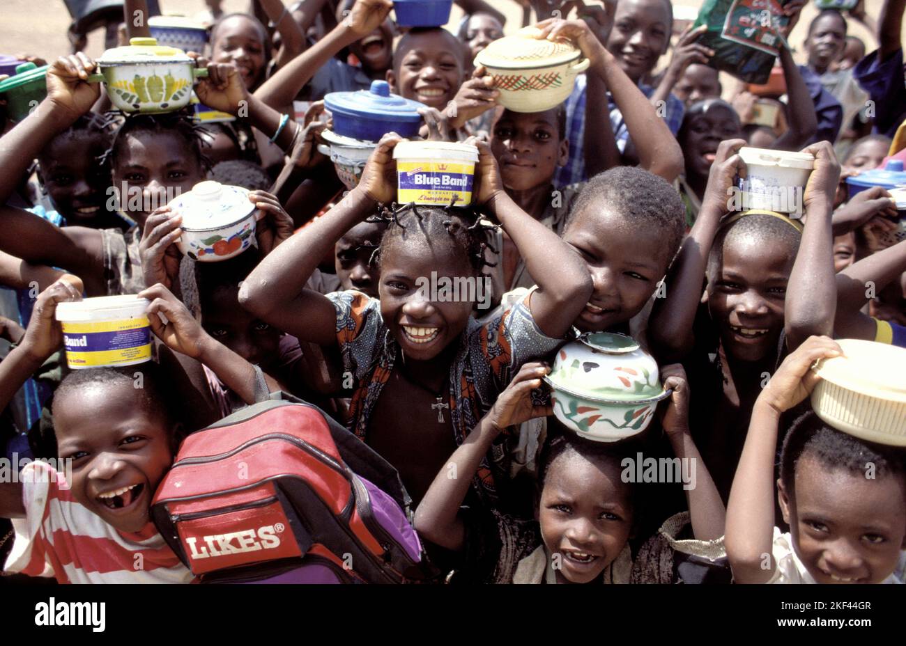 Burkina Faso, Piela; Schoolchildren carrying their lunchbox on the head ...