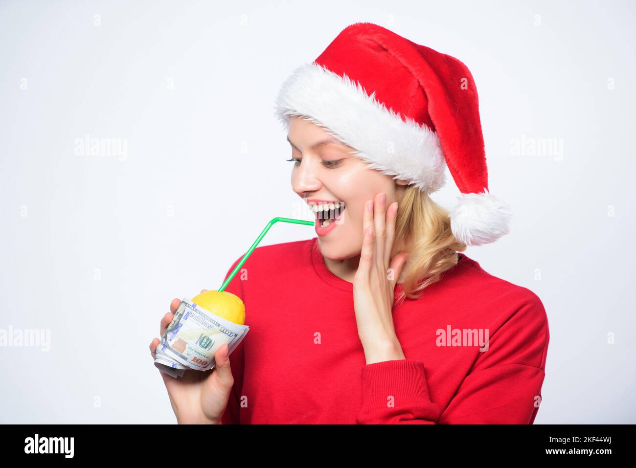 Lemon money concept. Girl santa hat drink juice lemon wrapped in ...