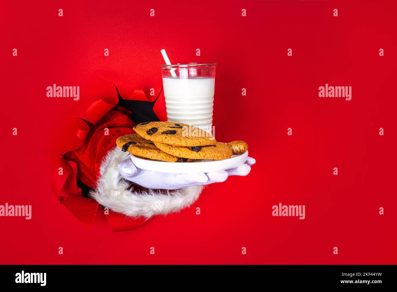 Hand of Santa Claus with traditional Christmas cookie snack with milk ...