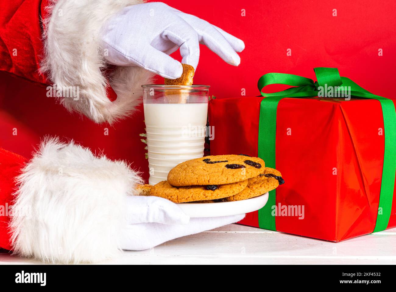 Hand of Santa Claus with traditional Christmas cookie snack with milk ...