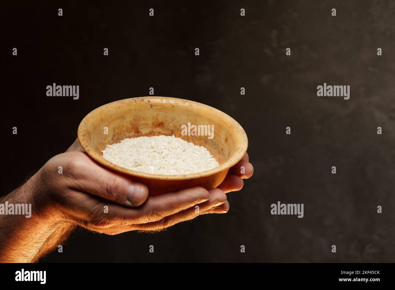Hands holding a heap of dry rice grain on black background Stock Photo ...