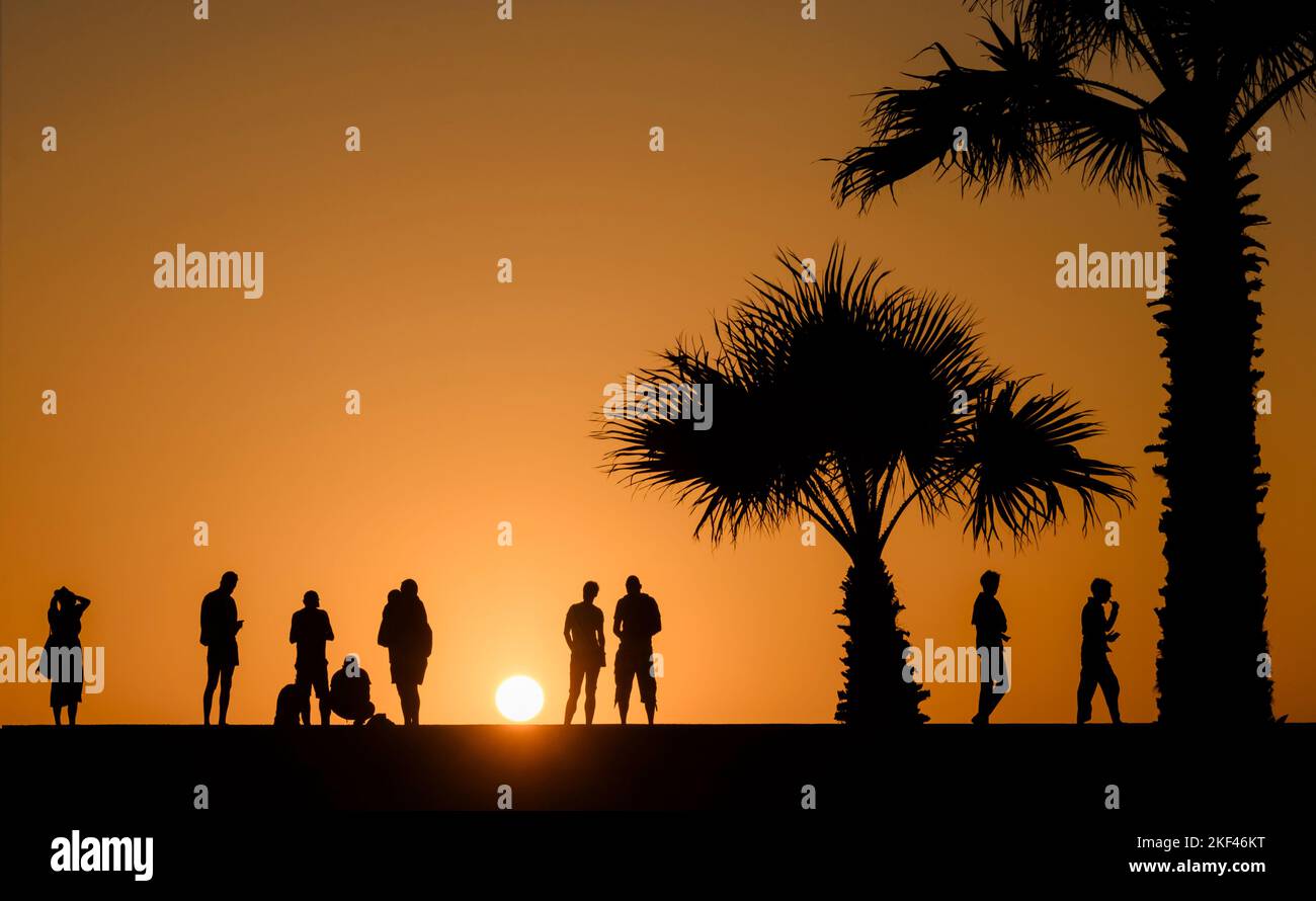 Silhouettes of people standing at Maspalomas lighthouse deck and ...