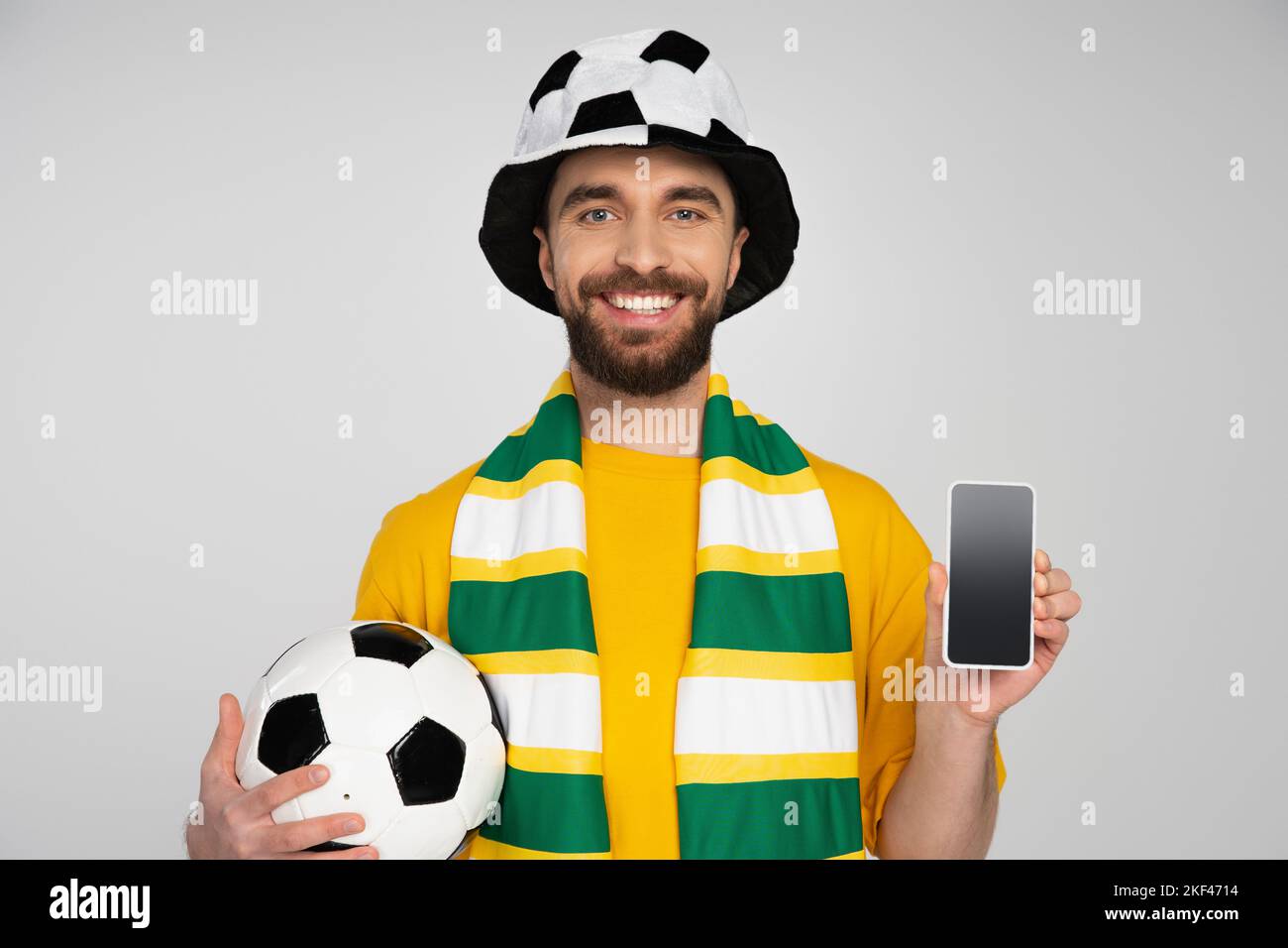 happy football fan holding soccer ball and showing smartphone with ...