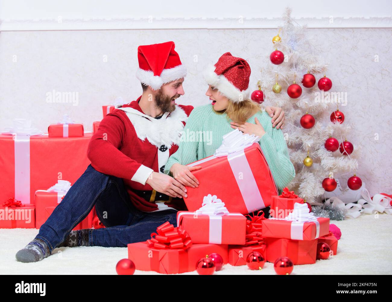 Loving couple unpacking gift christmas tree background. Couple in love ...