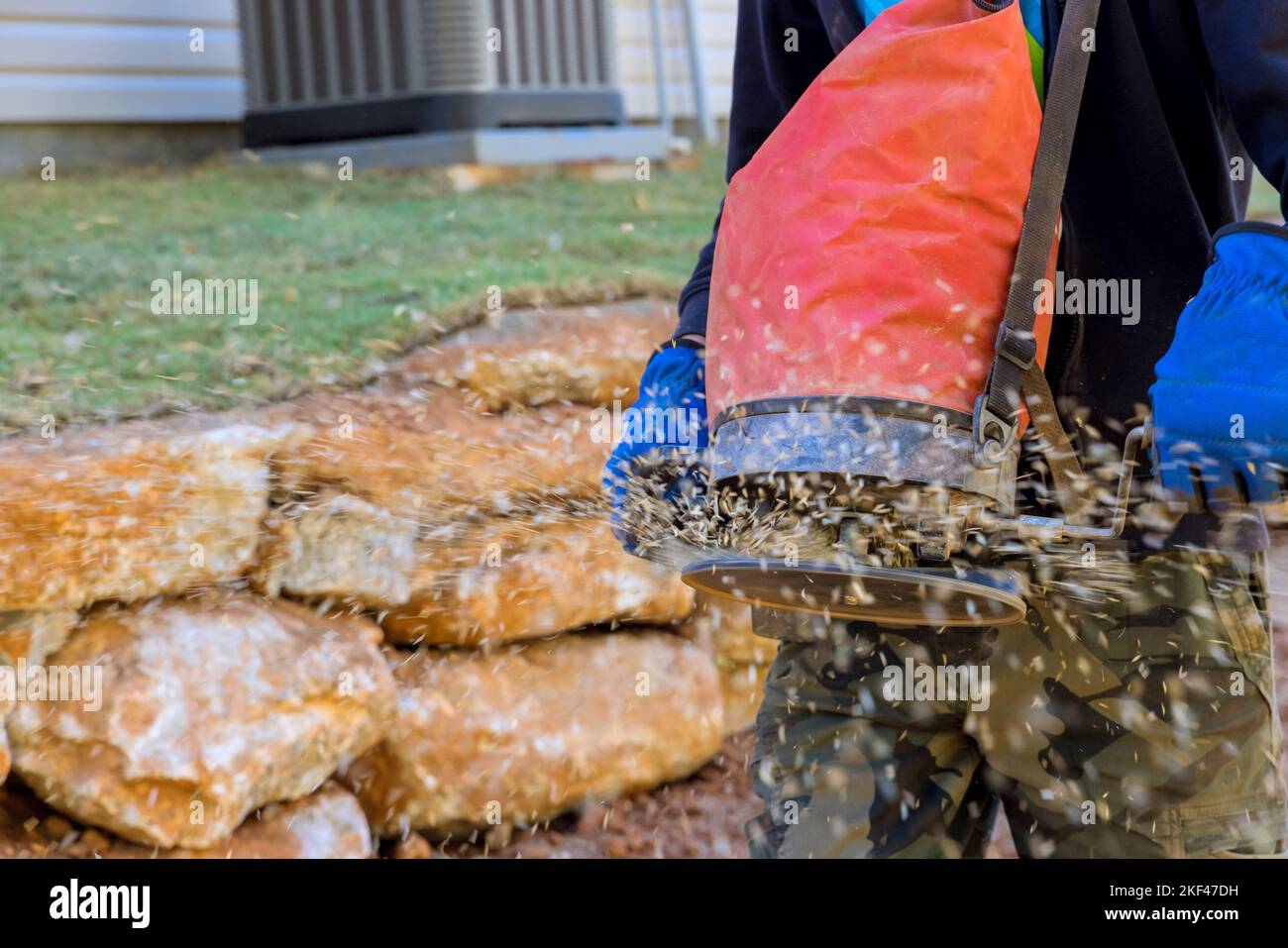 As part of landscaping project, landscapers use seeding device to sow ...