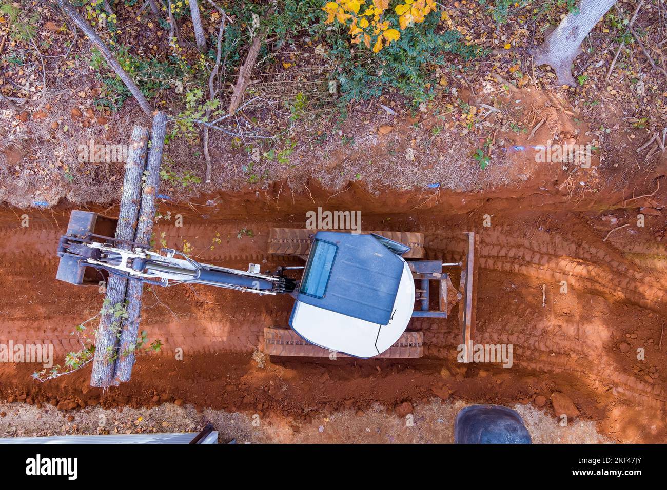 In process preparing land for construction tractor manipulator lifts ...