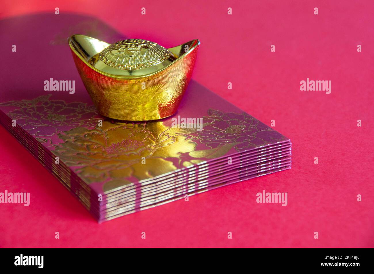 Close up of Gold ingot on top of Chinese New Year packets. Chinese new ...