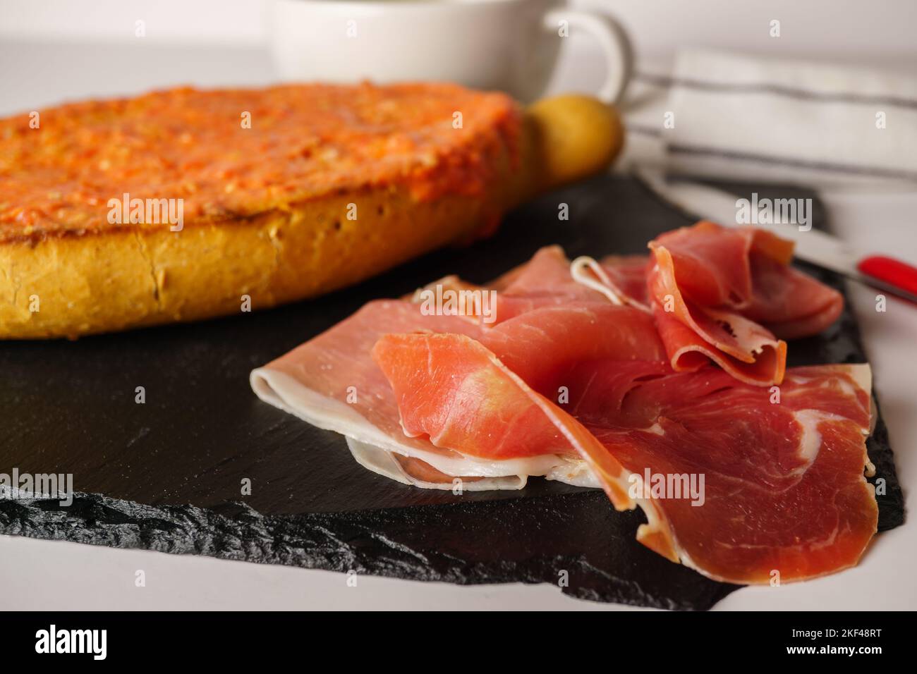 slice of bread with tomato, iberian ham and a cup of coffee typical ...