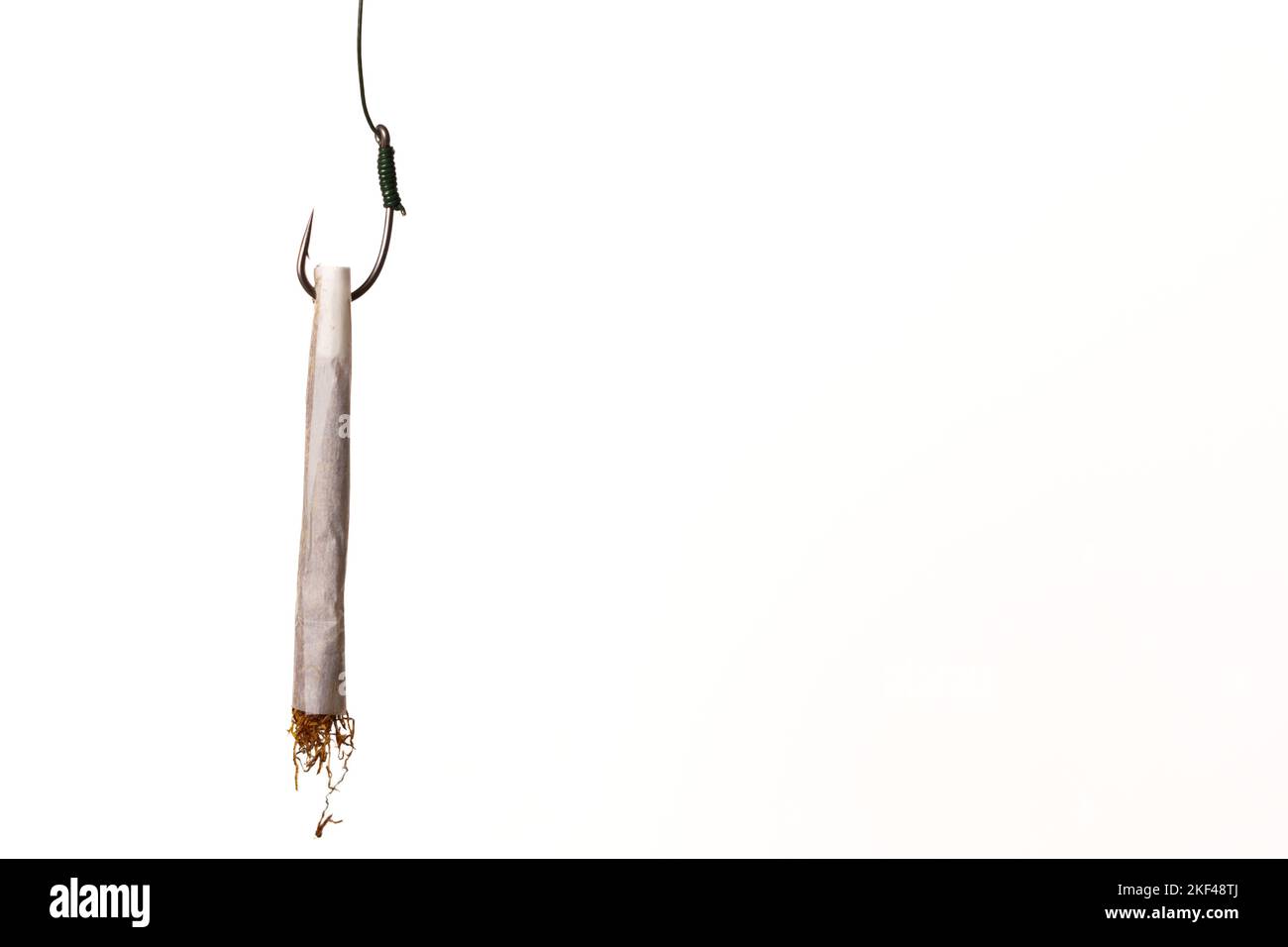 marijuana cigarette hanging from a hook drug addiction concept close-up ...