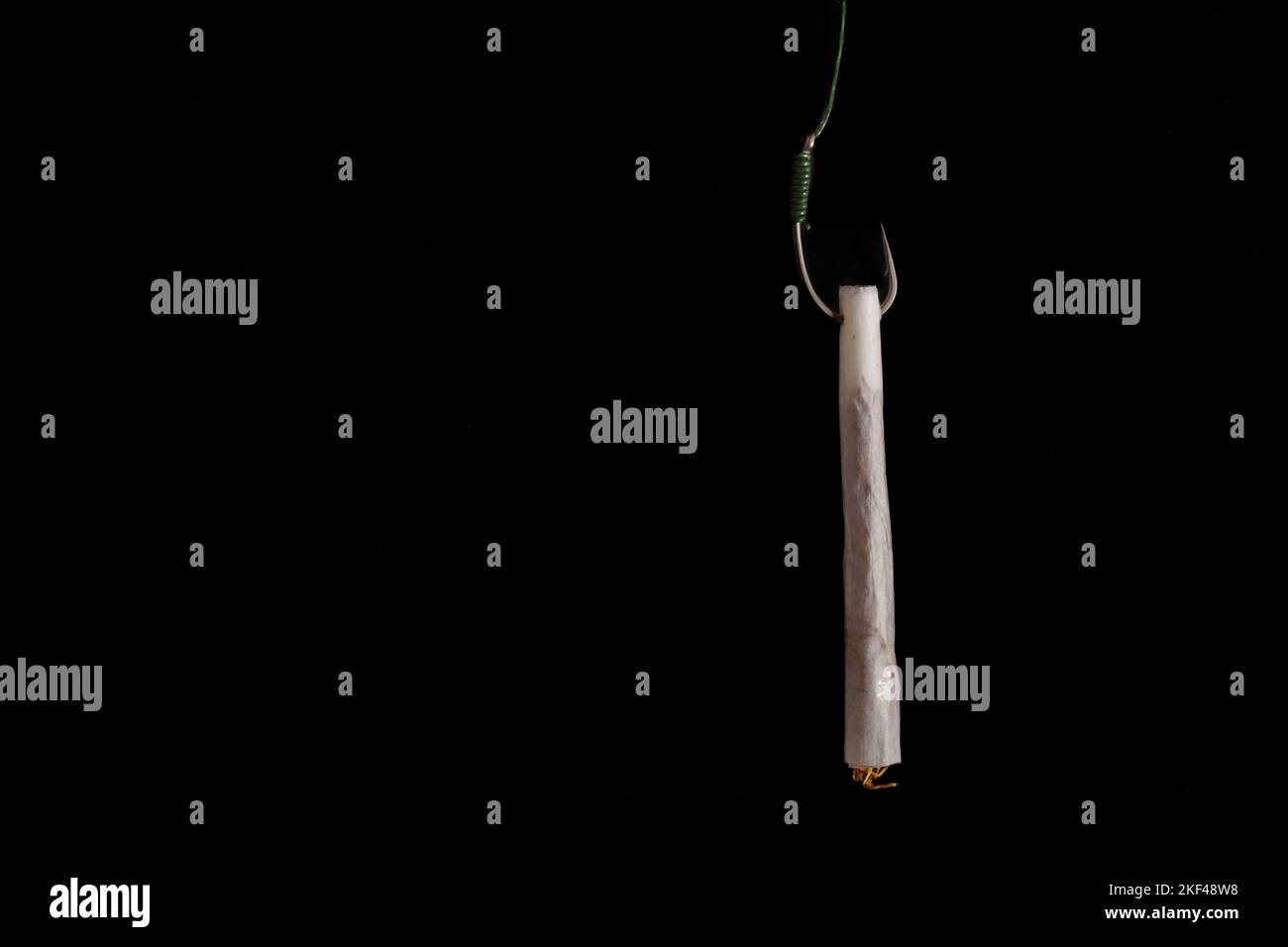 marijuana cigarette hanging from a hook drug addiction concept close-up ...