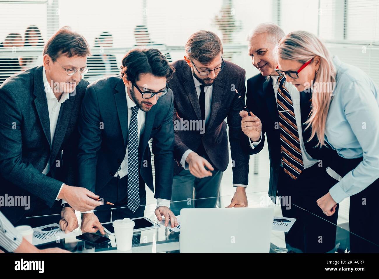 group of employees enthusiastically looking at the laptop screen Stock ...