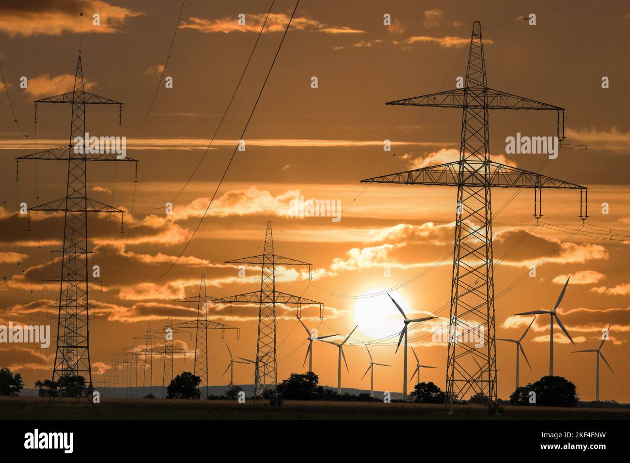 Windräder und Strommasten vor Sonnenuntergang, alternative Energie ...