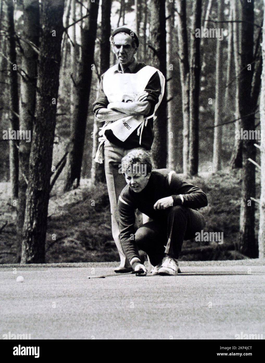 Christine Sharp lines up a putt on the 13th green while her caddy gives ...