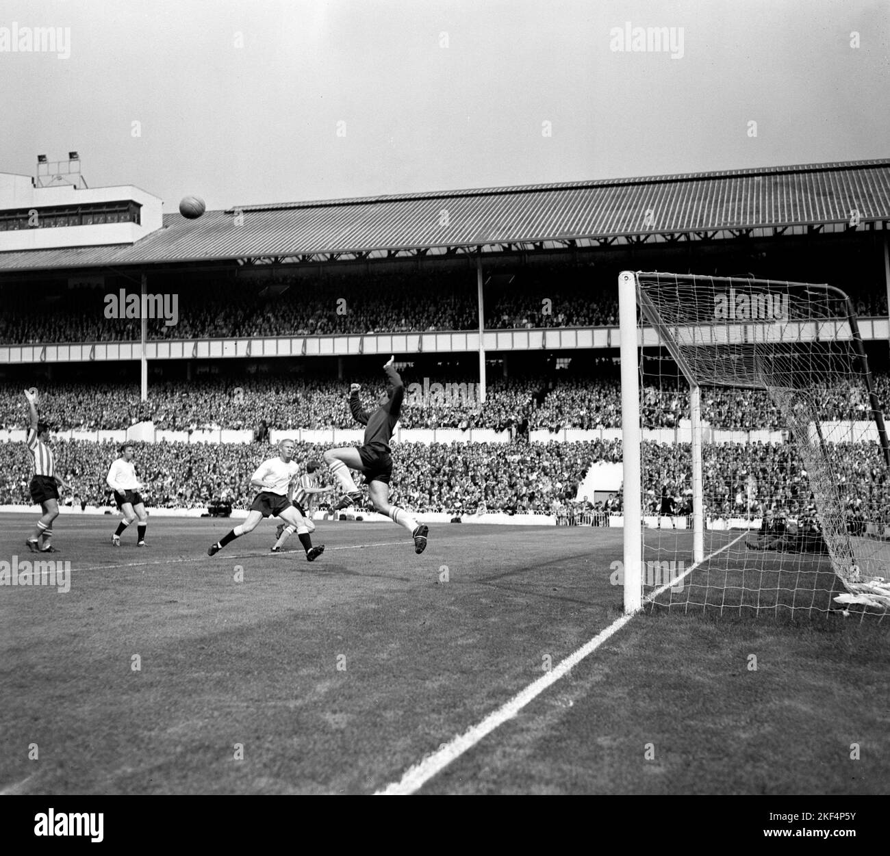 Alan Hodgkinson (Sheffield's goalkeeper) punches clear a shot from ...