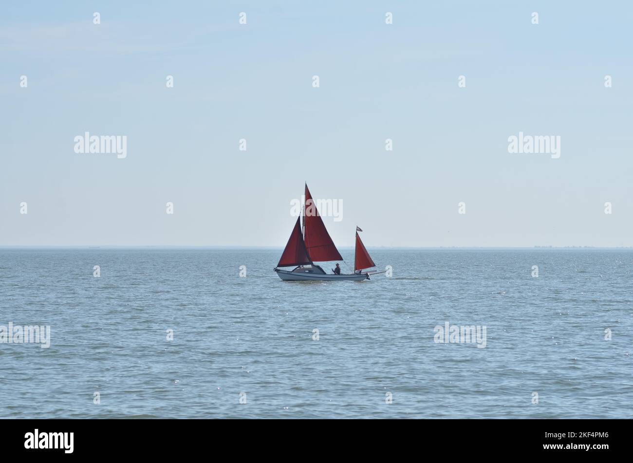 Sailing. Sailboat with red sails blue sky and rippled sea background ...