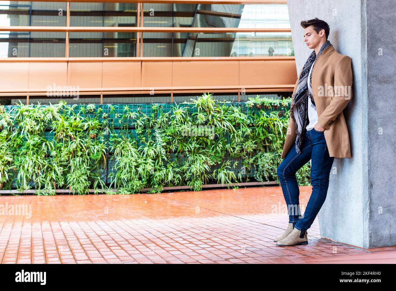 Young man wearing winter clothes in the street. Young guy with modern ...