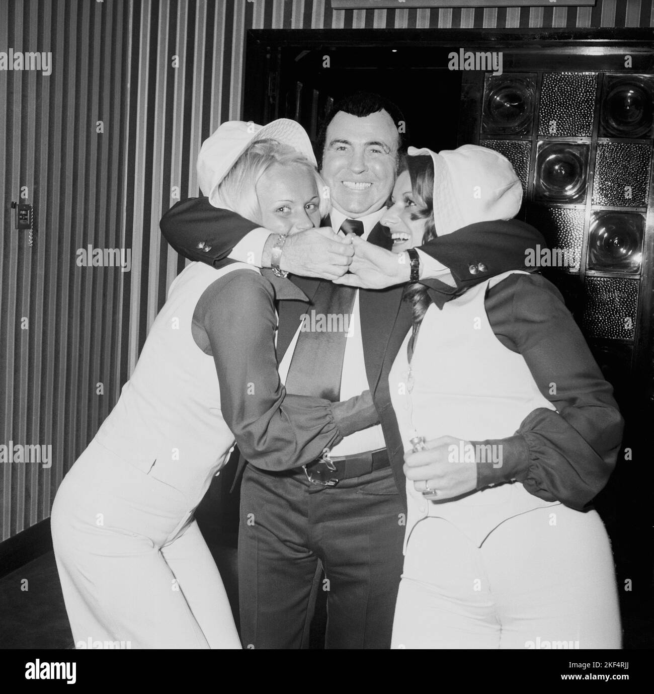 Wrestler Mick McManus (c) performs a double headlock on two employees ...