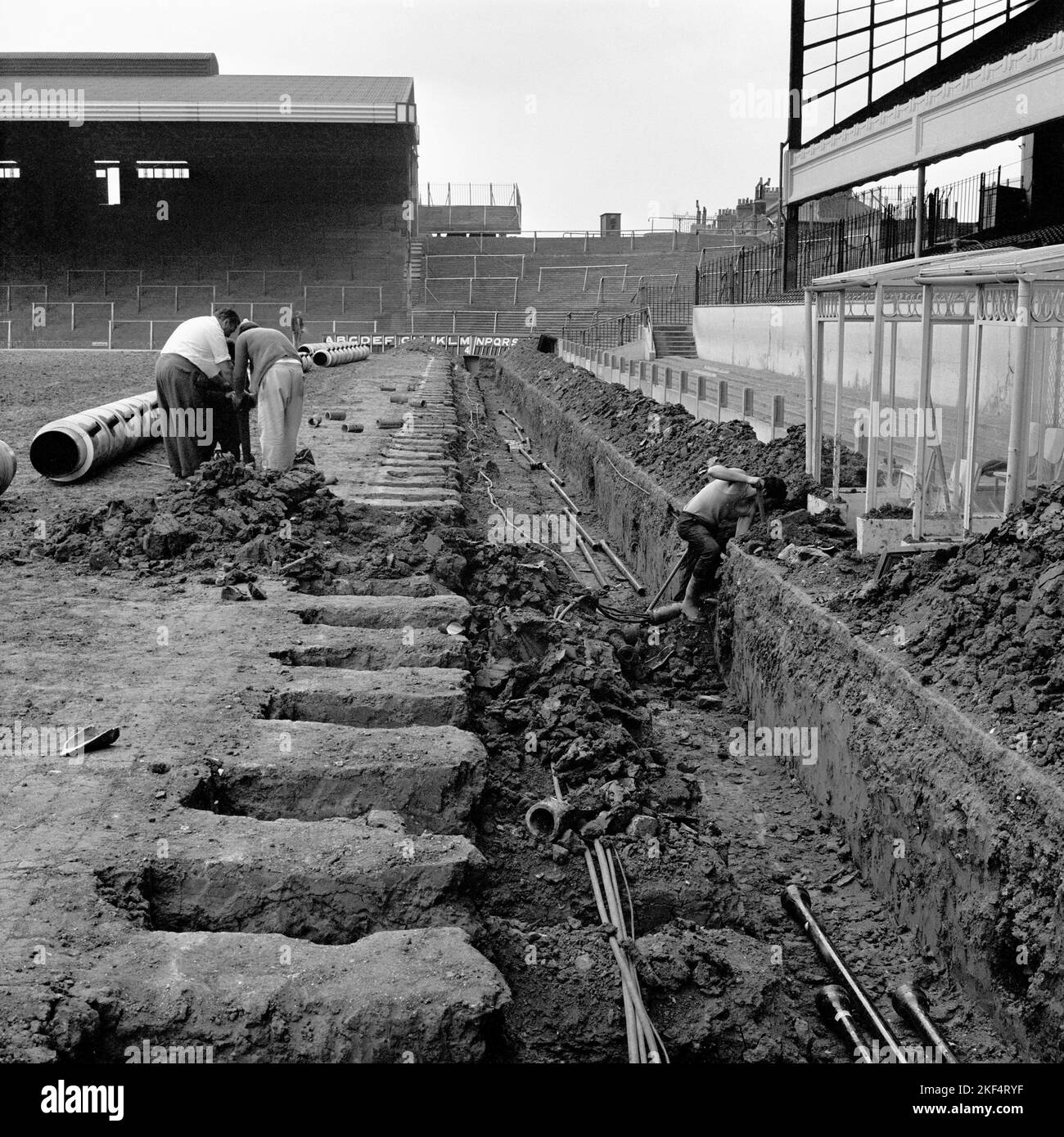 Workmen finish digging out the trench at pitchside which will house the ...