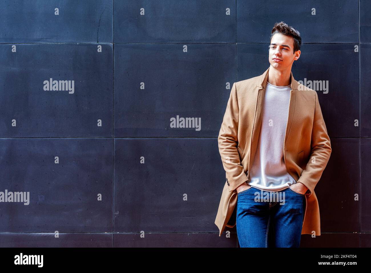 Young man wearing winter clothes in the street. Young guy with modern ...