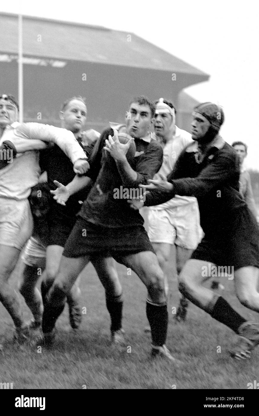 New Zealand's Colin Meads (c) emerges from a loose maul with the ball ...