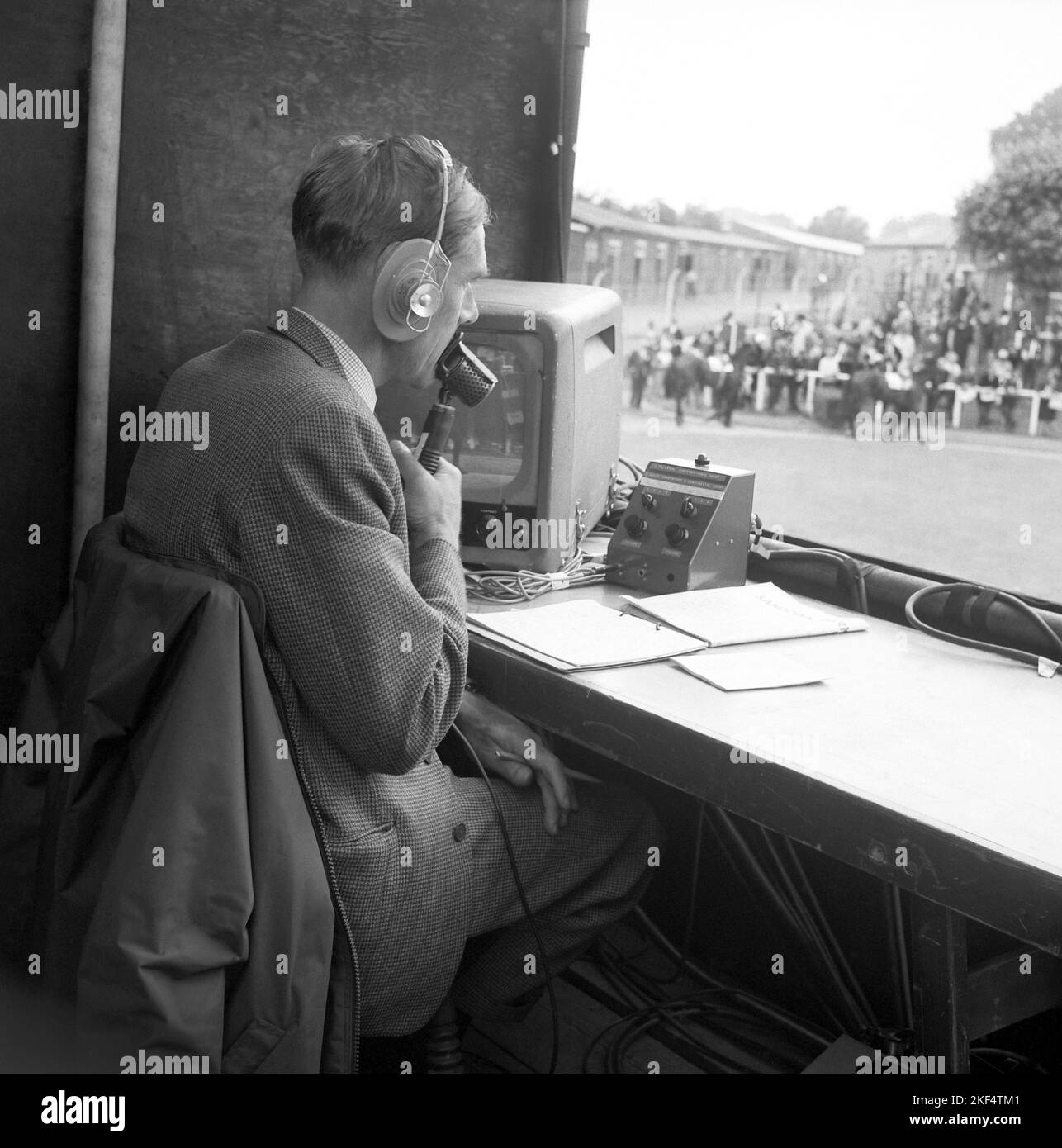 Race announcer and commentator at his desk at Sandown Park racecourse ...