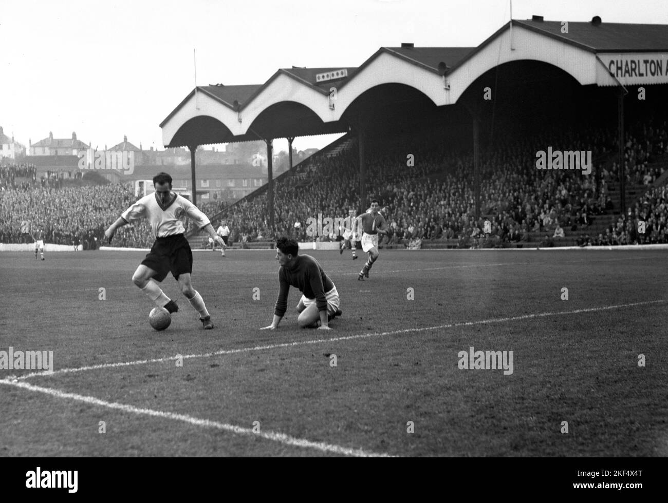 Charlton goalkeeper Willie Duff (r) goes on hands and knees as he ...
