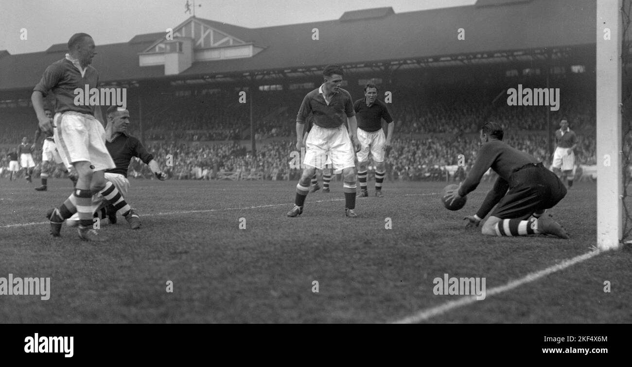 Liverpool goalkeeper Arthur Riley (r) saves, watched by teammate Matt ...