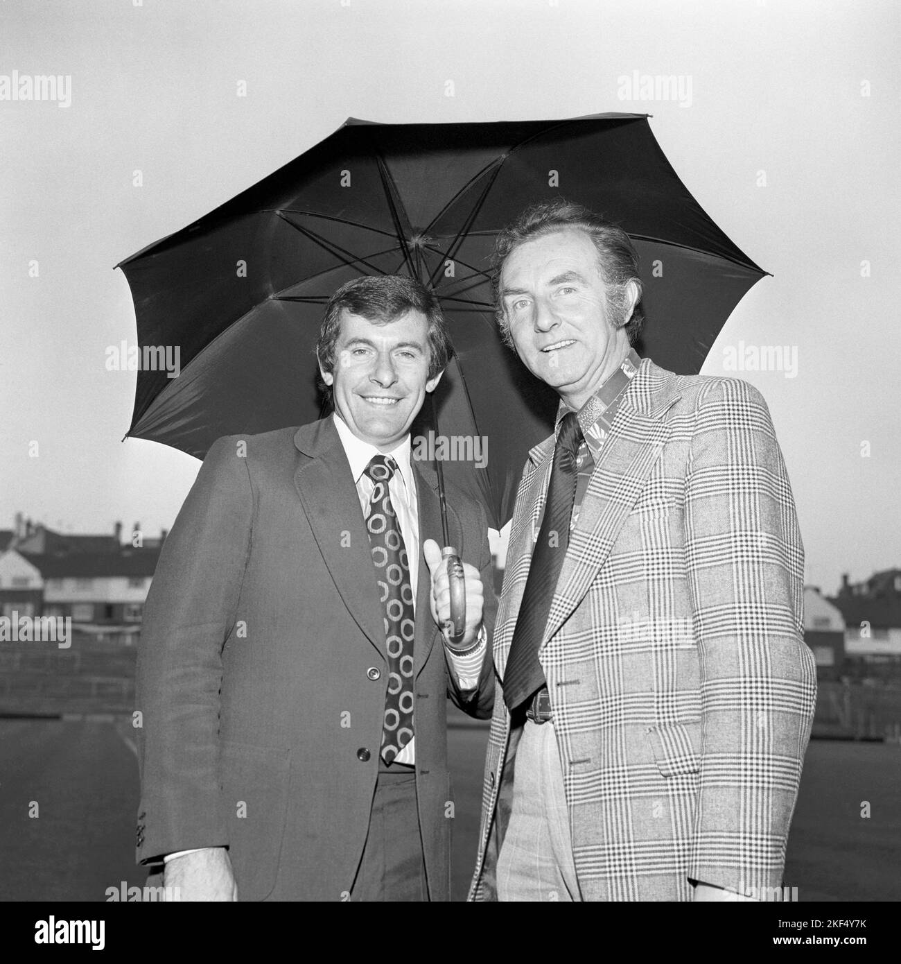 Brighton and Hove Albion chairman Mike Bamber (r) shares un umbrella ...