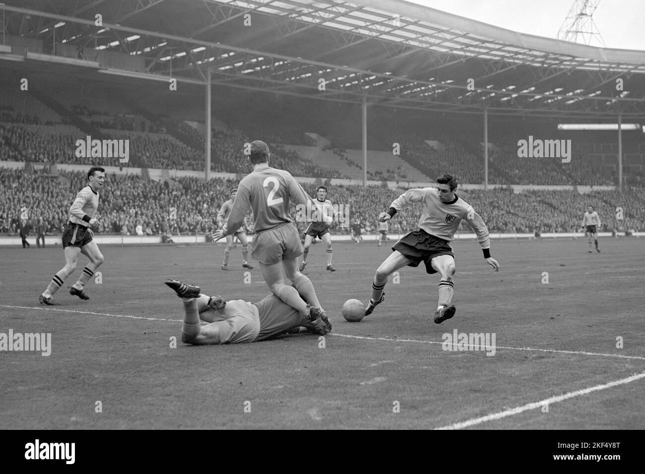 Enfield goalkeeper M Mitchell (second l) dives at the feet of Crook ...