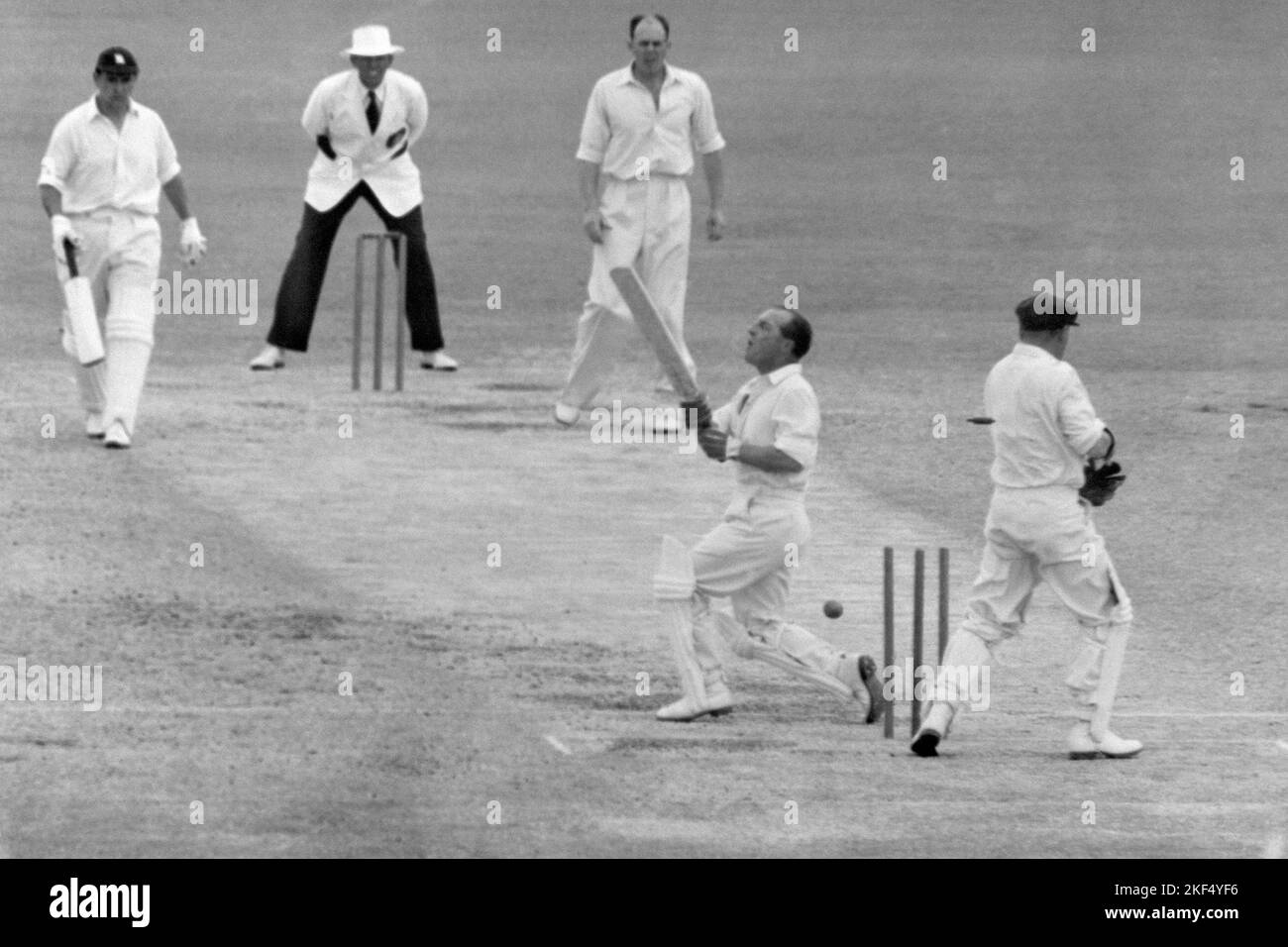England's Bill Edrich (second r) is bowled by Australia's Bill Johnston (c) for 88 as teammate ...