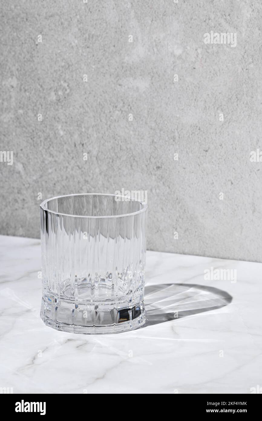 Empty facetted glass over grey background Stock Photo - Alamy